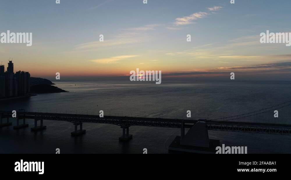 Sunrise behind the Gwangandaegyo bridge at the Gwangalli Beach in Busan ...