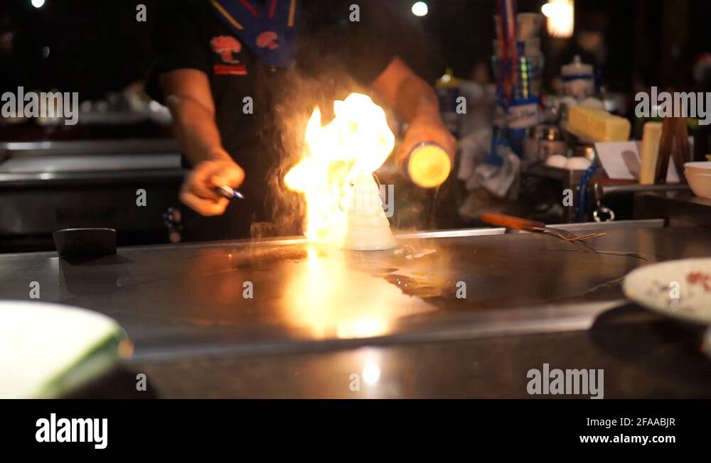 Hibachi chef is giving a fire show at a Japanese restaurant Stock Video ...