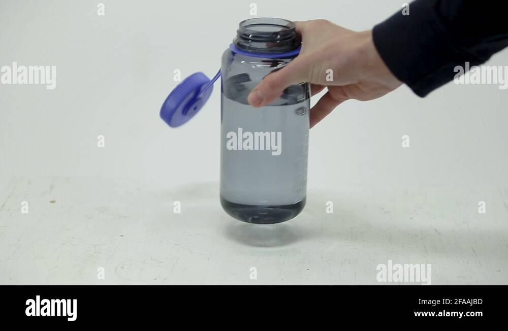 Dropping a dry ice cube into a water bottle Stock Video Footage - Alamy
