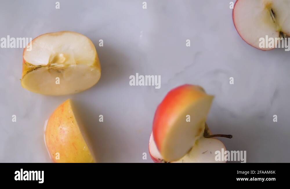 Slice of apple falling into milky water with splashes in slowmotion ...
