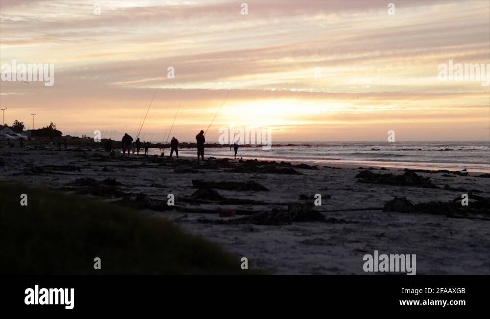Fisherman fishing on a beach in South Africa's west coast just as the ...