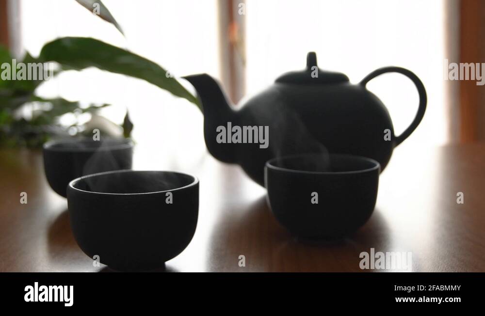 minimal background of a green japanese tea set with steam coming out of ...