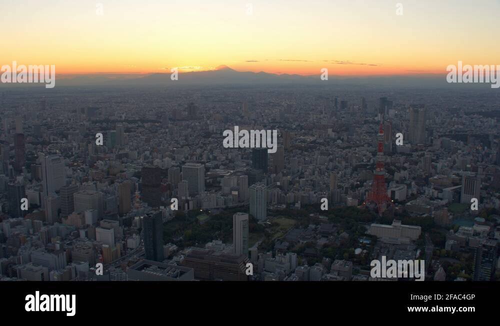 Tokyo, Japan circa-2018. Flying over Tokyo Tower as sun sets behind ...