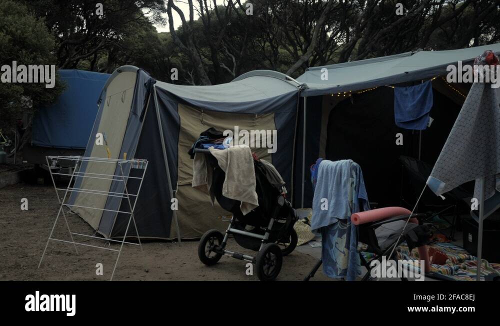 Messy family tent set up and a camping ground in Australia. PAN RIGHT ...