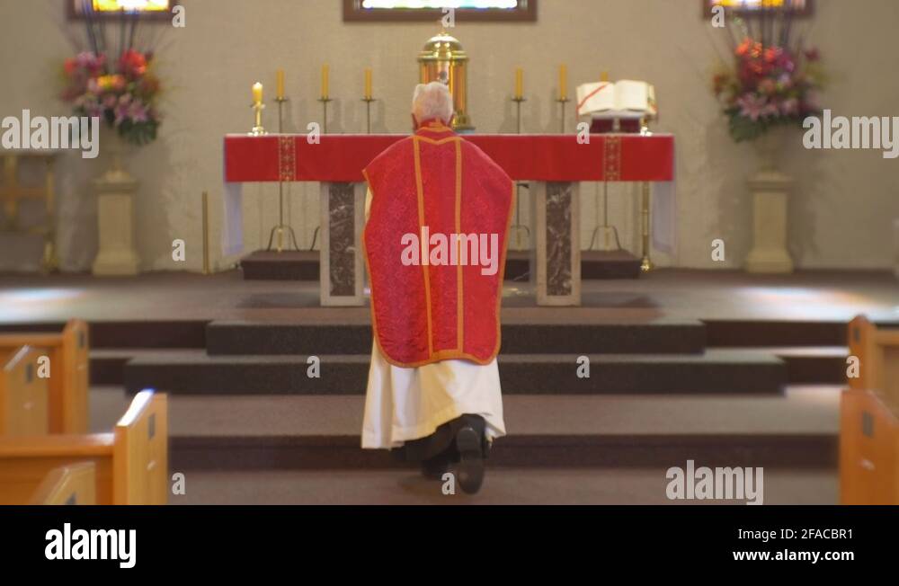Genuflecting priest kneeling before altar Stock Video Footage - Alamy