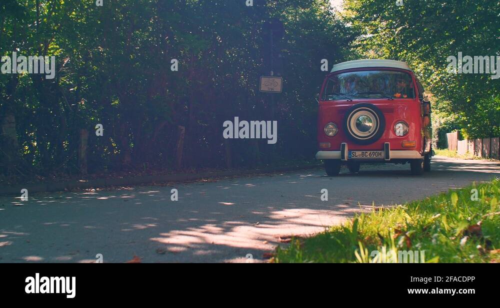 Couple of friends driving around the countryside in red a bus having a ...