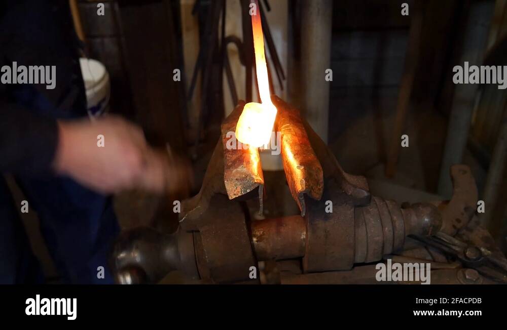 Bending Hot Metal in the Blacksmith Vise and Tongs to Create a ...
