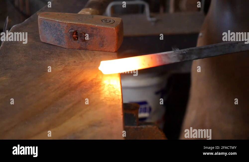 A Blacksmith Forging A Shoulder on a Bar of Steel at the Anvil in the ...