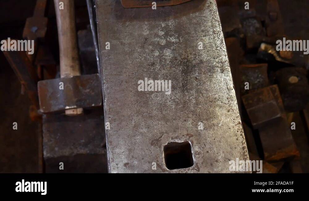 A Blacksmith Forging a Chisel on Molten Hot Metal Bar in the Black ...