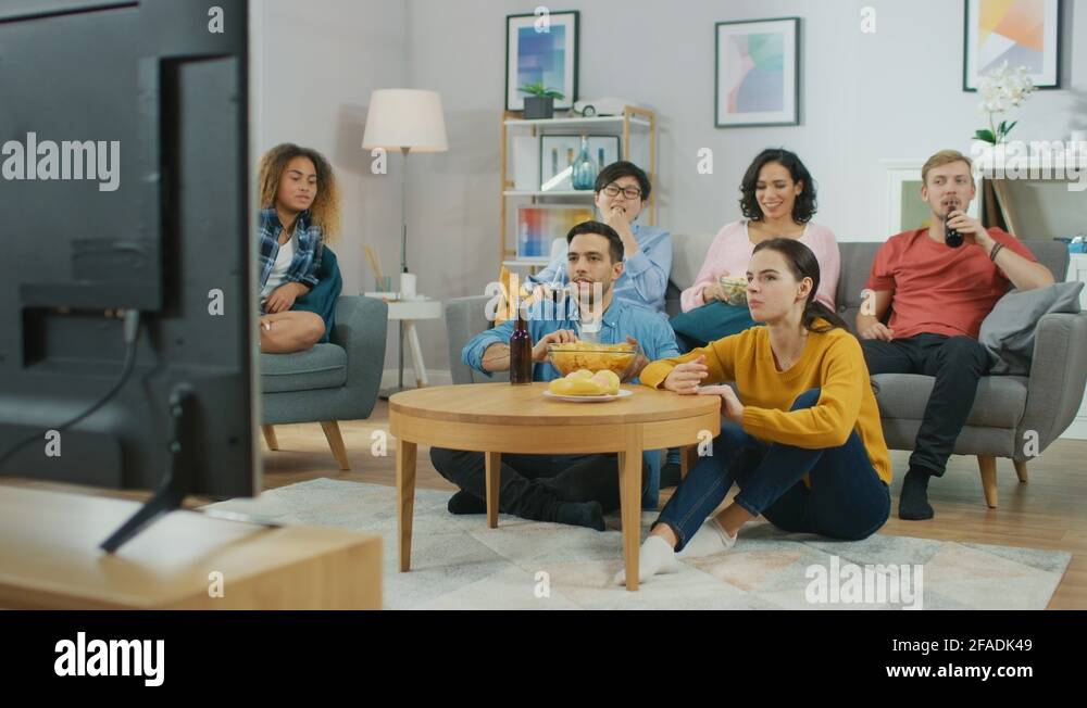 At Home Diverse Group Friends Watching TV Together, Eating Snacks and ...