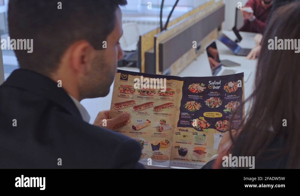 Girl choosing sandwich from the food flyer in the office Stock Video ...