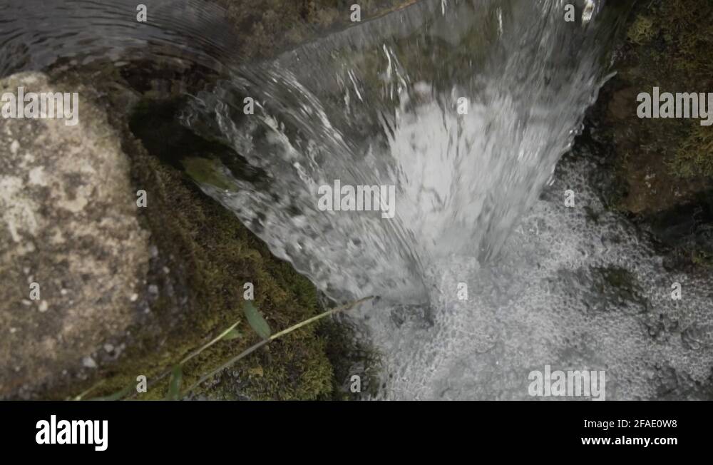 Looking straight down on water falling into a pool and causing bubbles ...