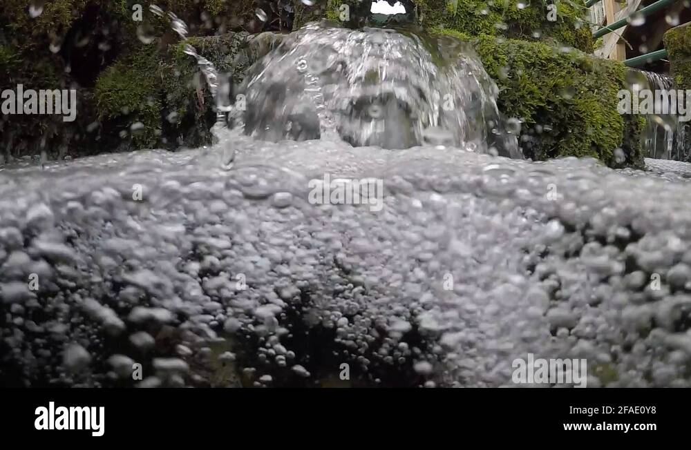 Half screen of water pouring and bubbles below the surface of water ...