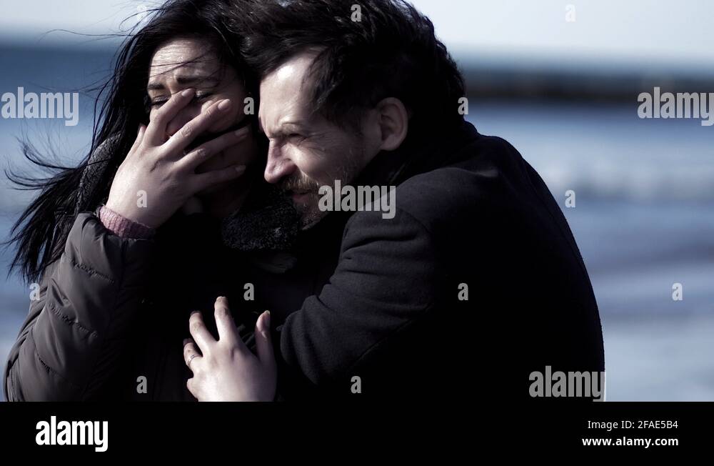Man hugging woman desperate crying feeling pain and sorrow in front of ...