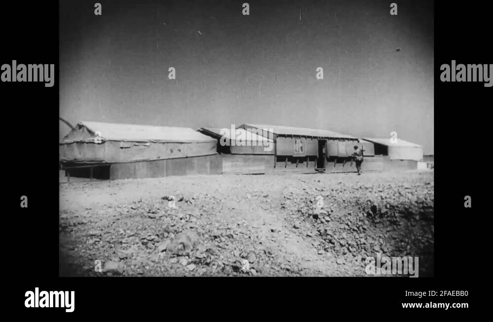 Camouflaged antiaircraft guns are manned to air raid and balloon is ...