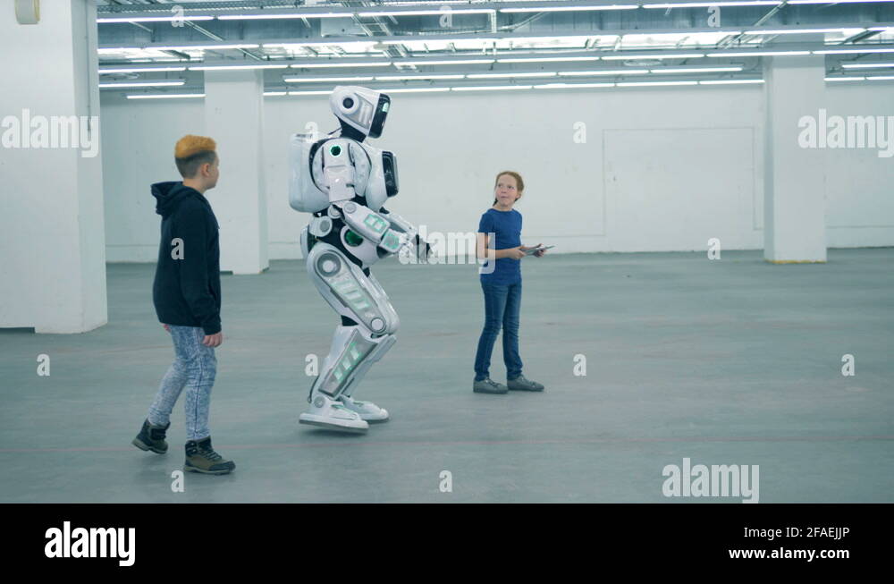 Two kids are controlling walking process of a human-like cyborg Stock ...