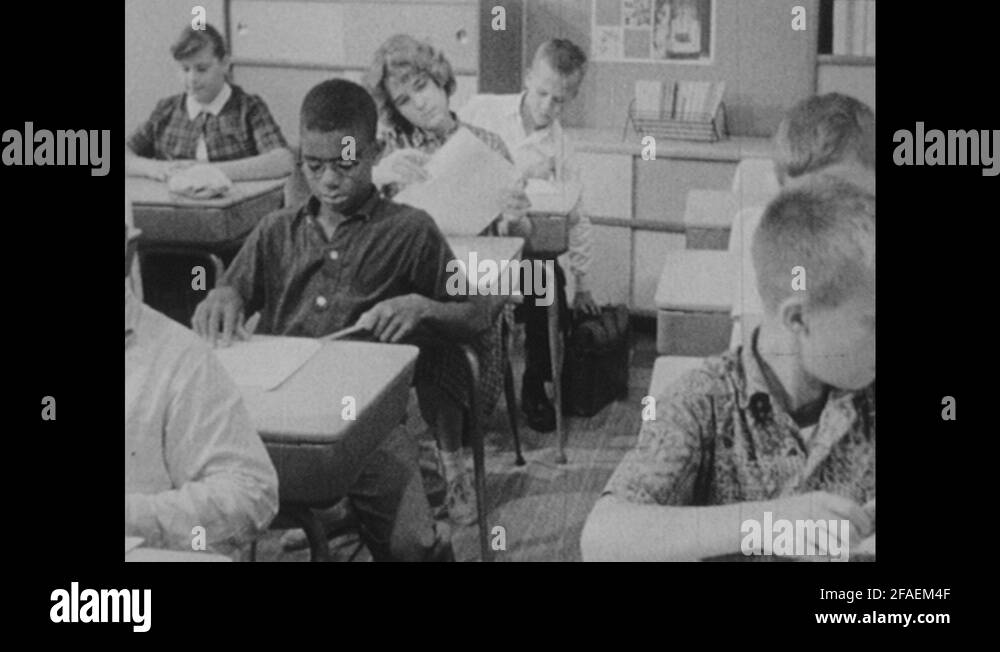 1960s: Children pass completed tests to front of class Stock Video ...