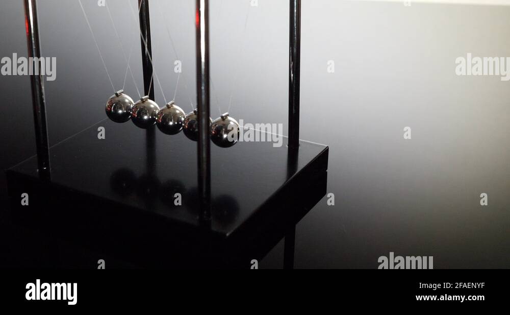A Newtons cradle demonstrating laws of physics and the principle of ...