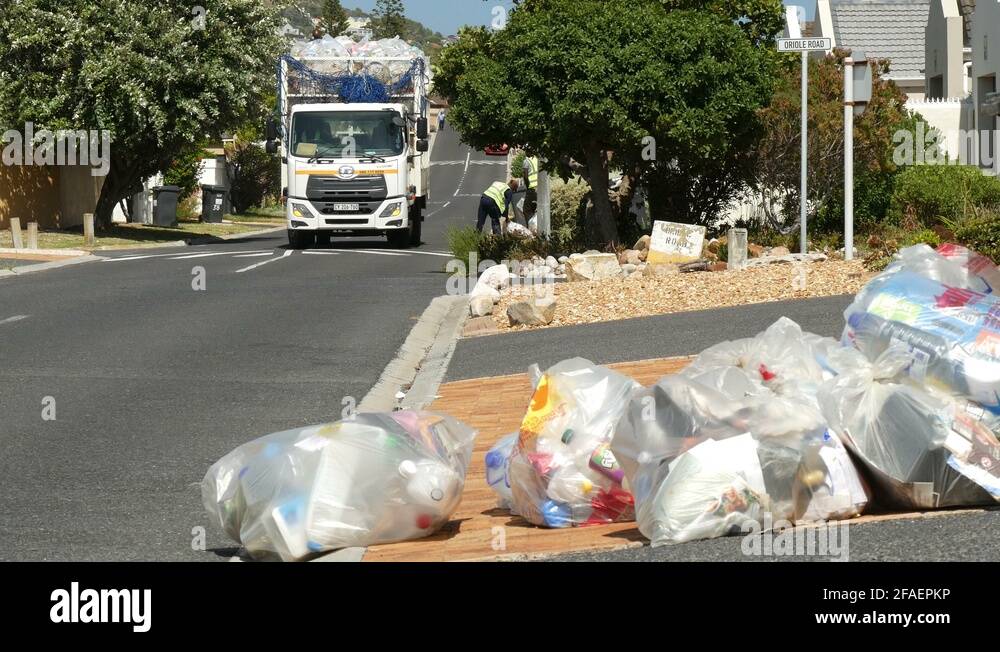 Plastic bags of garbage on side walk with recycling waste collection ...