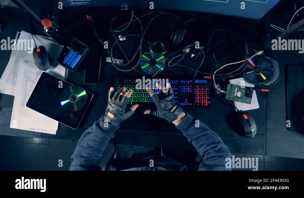 Cyber crime concept. Man typing on colored keyboard while hacking, top ...