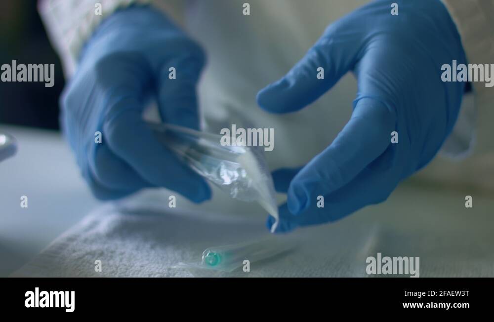 Doctor opens sterile syringe packaging for medical injection Stock ...