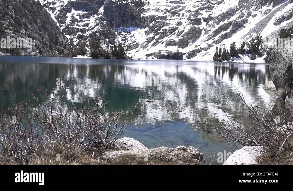 Rippling water on an alpine lake surround by granite mountains Stock ...