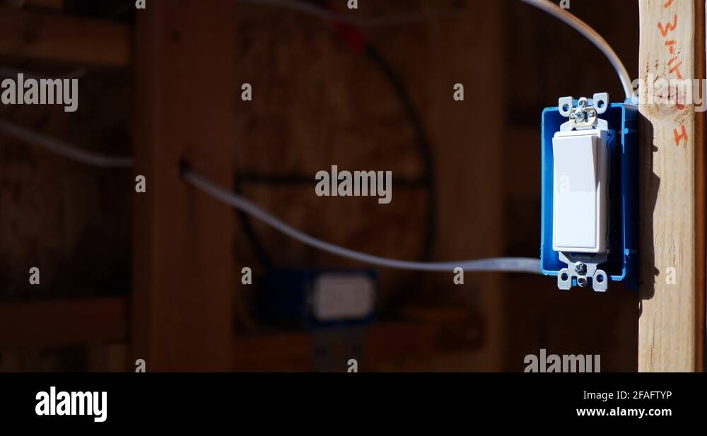 A light switch on the unfinished lumber framing of a new home on a ...