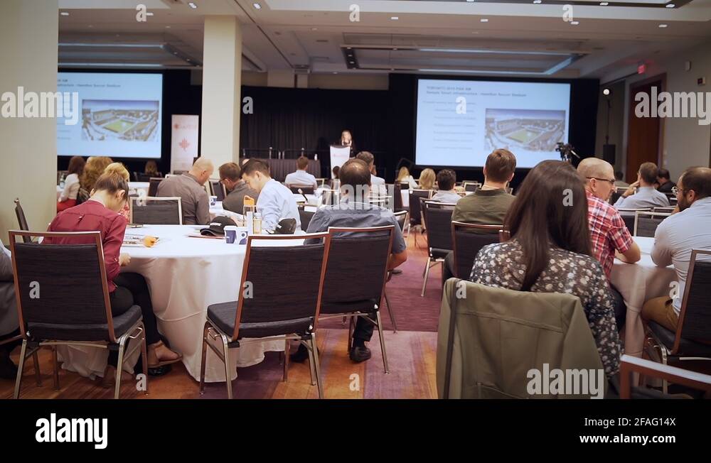 Keynote speaker giving a presentation during a corporate conference ...
