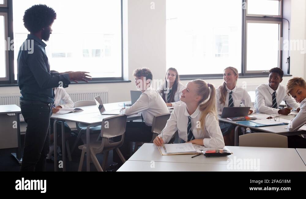 Male High School Teacher Standing In Classroom Teaching Lesson To ...