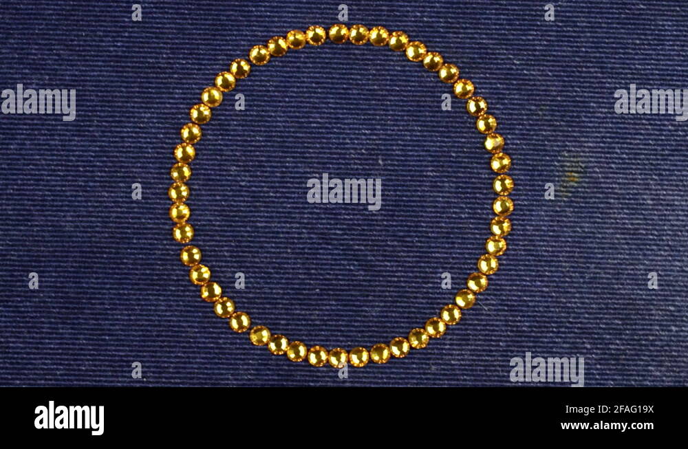 Rotation of a circle made of yellow rhinestones, the symbol of infinity ...
