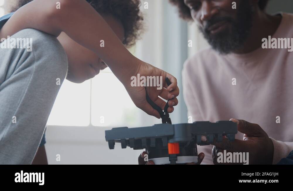 Close up of pre teen boy constructing a kit toy using pliers, his ...