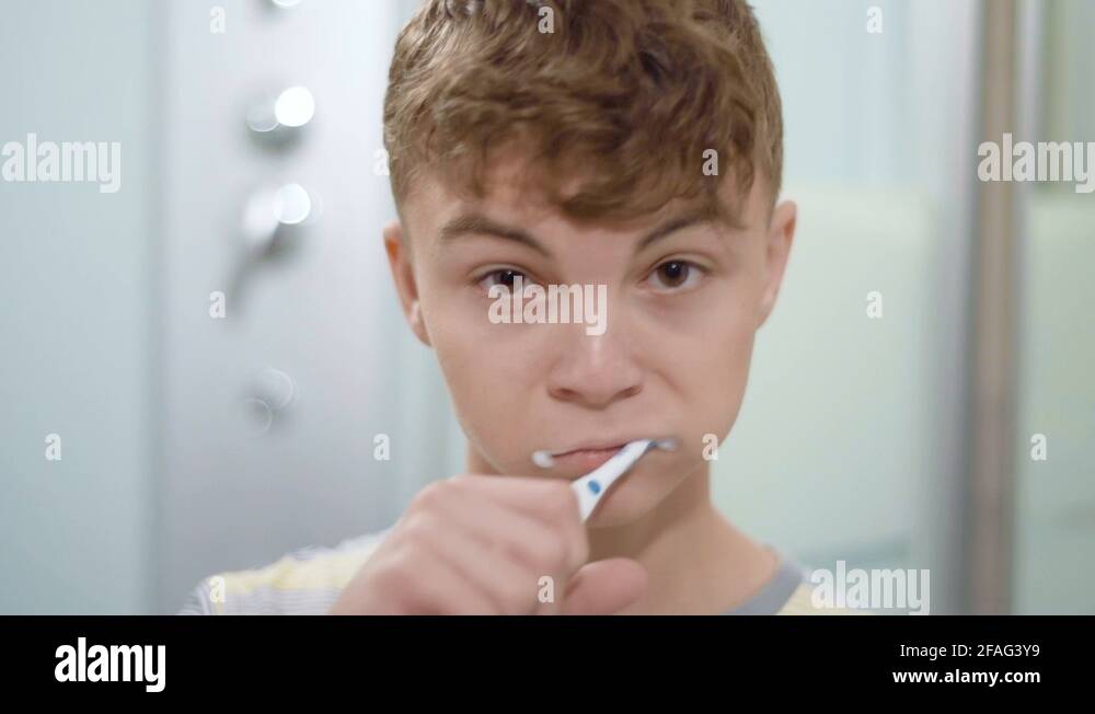 Teen boy brushing teeth Stock Video Footage - Alamy