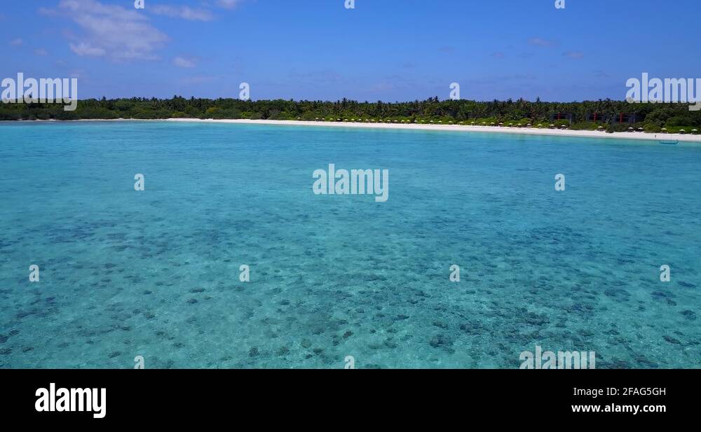 Calm sea with clear water and reef in the Maldives, resort on beach in ...