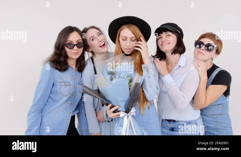 A group of women in denim clothes posing in a white studio. A bunch of ...