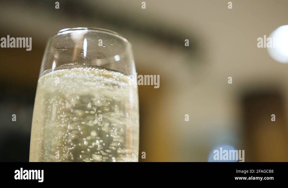 Low angle of champagne fizzing and someone dropping fruit into the ...