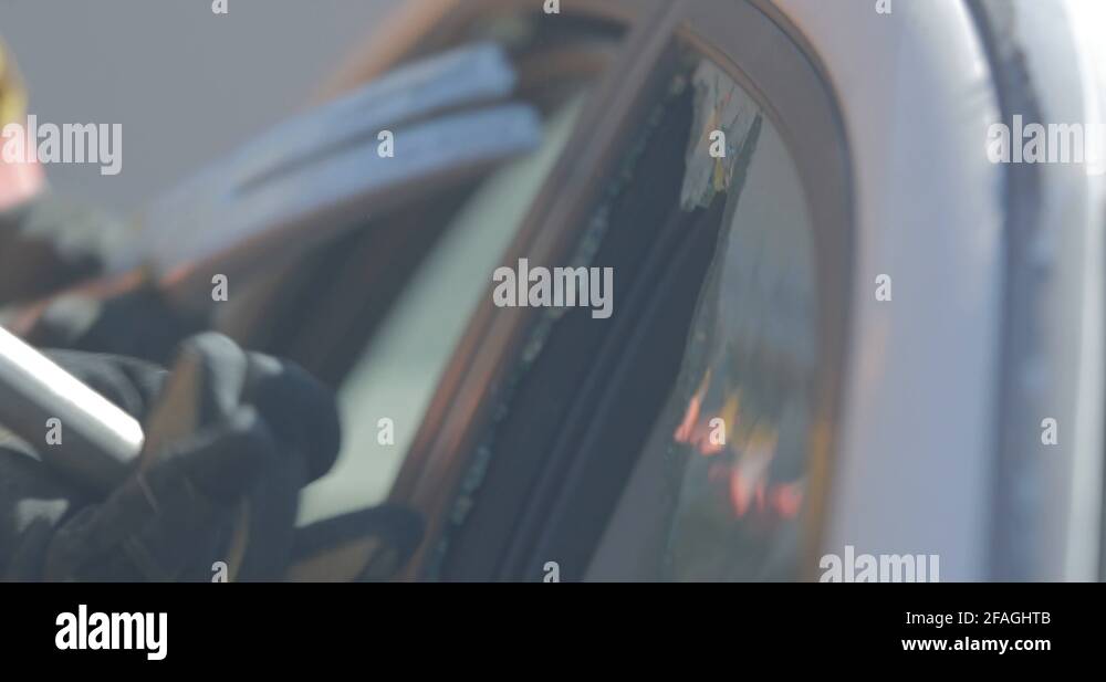 Firefighters break windows on a car during training for rescue and ...