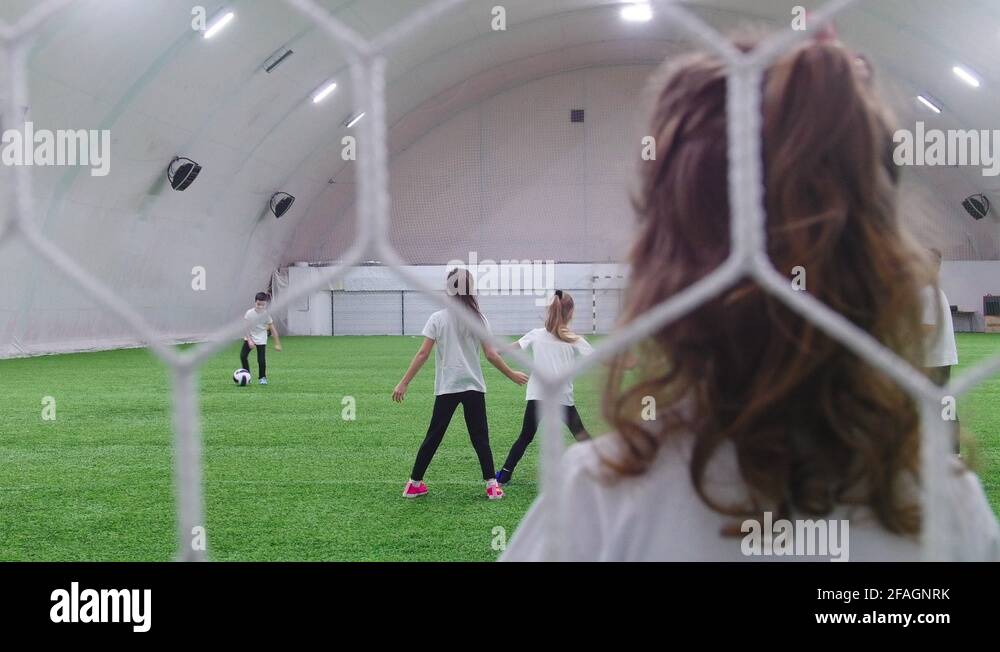 Indoor football arena. Little kids playing football. View behind the ...