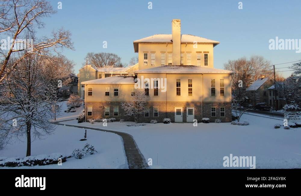 Rising shot from snow covering ground at Linden Hall to reveal sunrise ...