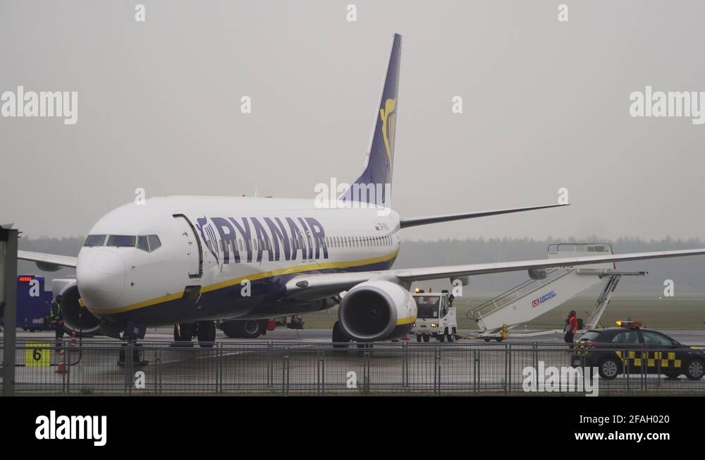Passenger aircraft parked at apron turmac with ground staff operating ...