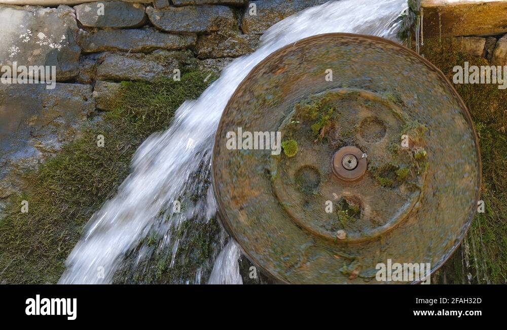 Falling water rotates a water wheel. Ancient method of extracting ...