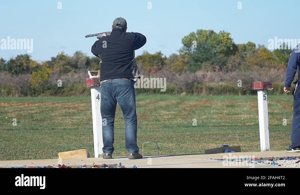 Making practice at a shooting range, a man aiming with a rifle, firing ...