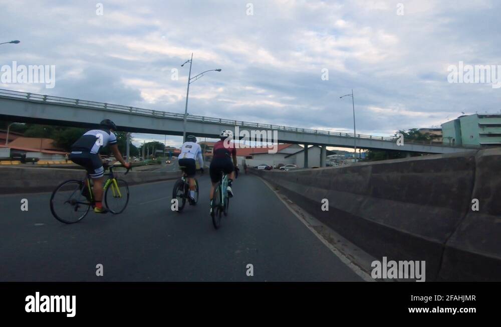 A group of cyclists riding their bikes on the freeway and past a police ...