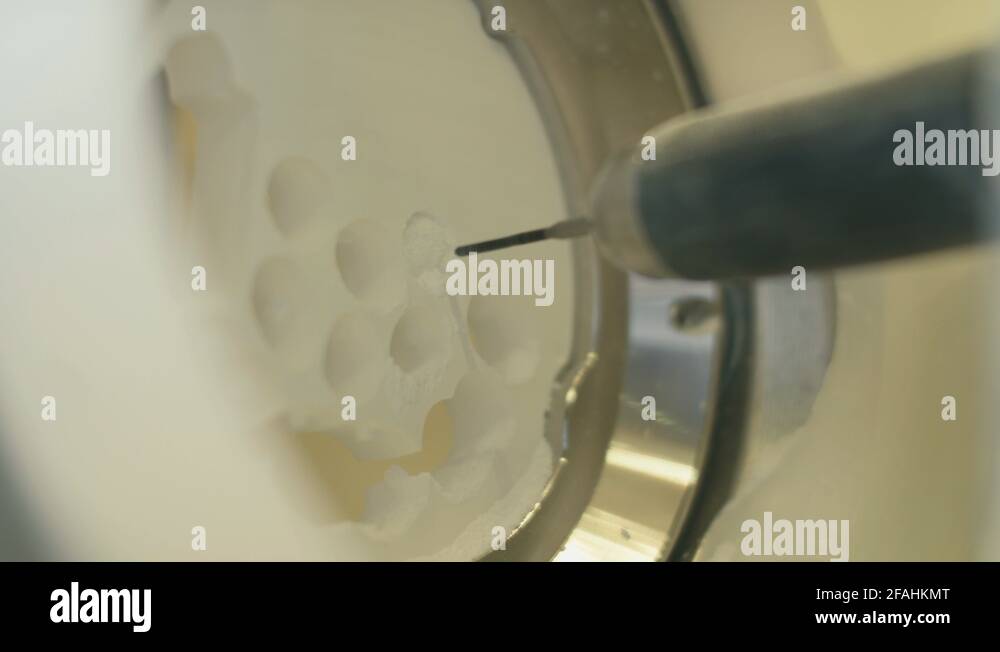 Dental milling cnc machine carving out shape of human teeth close-up ...