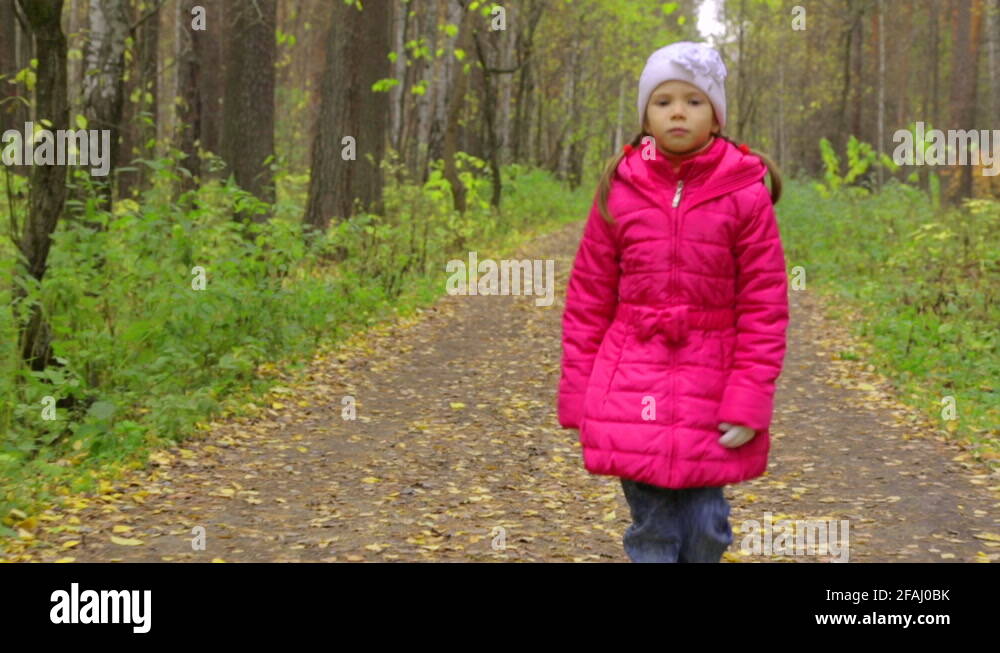 Little girl walking along a path in park Stock Video Footage - Alamy