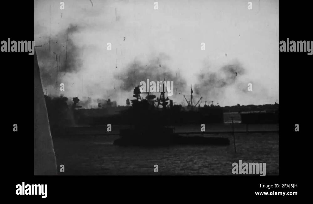 Men in devastated area, scene of burned ship in the sea - 1944 Stock ...