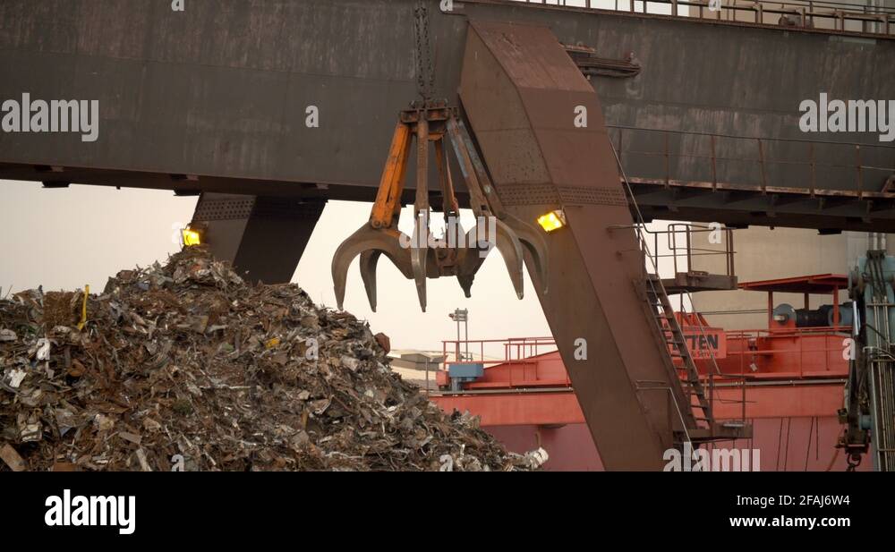 Crane picking up metal scrap into a ship, recycling company in Germany ...