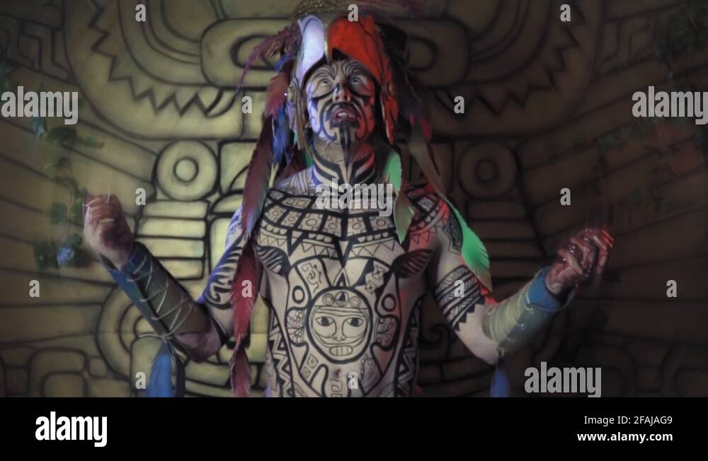 Aztec warrior with body paint on his body, is screaming and shaking ...