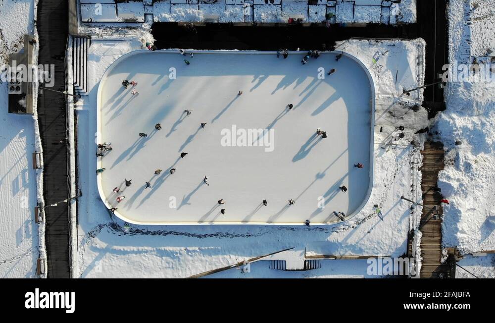 Ice rink with skating group of people. Top down aerial view on the ...