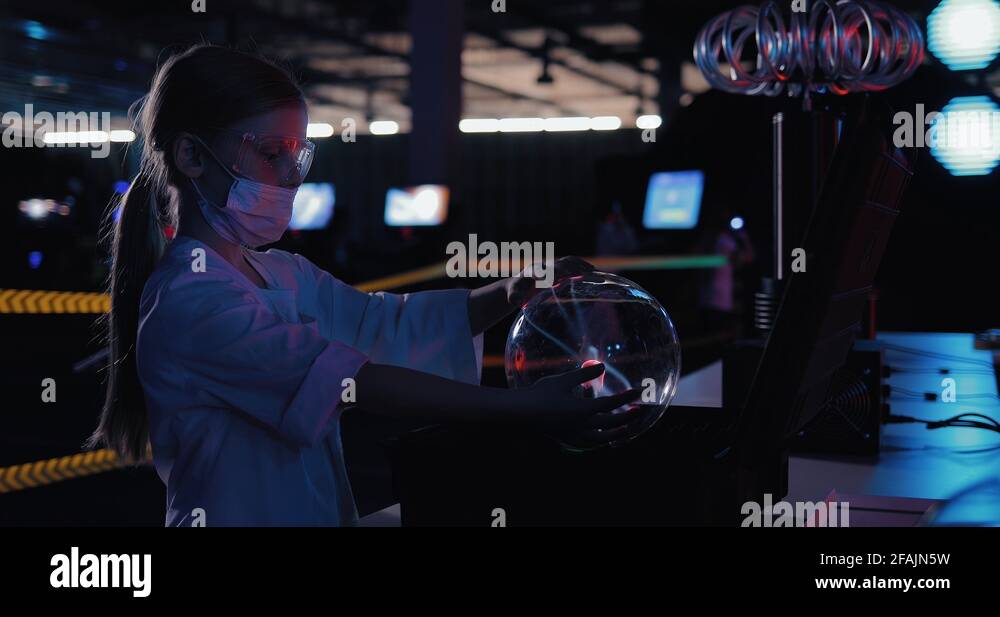 Girl laboratory assistant conducts a physical experiment. Glow ball ...