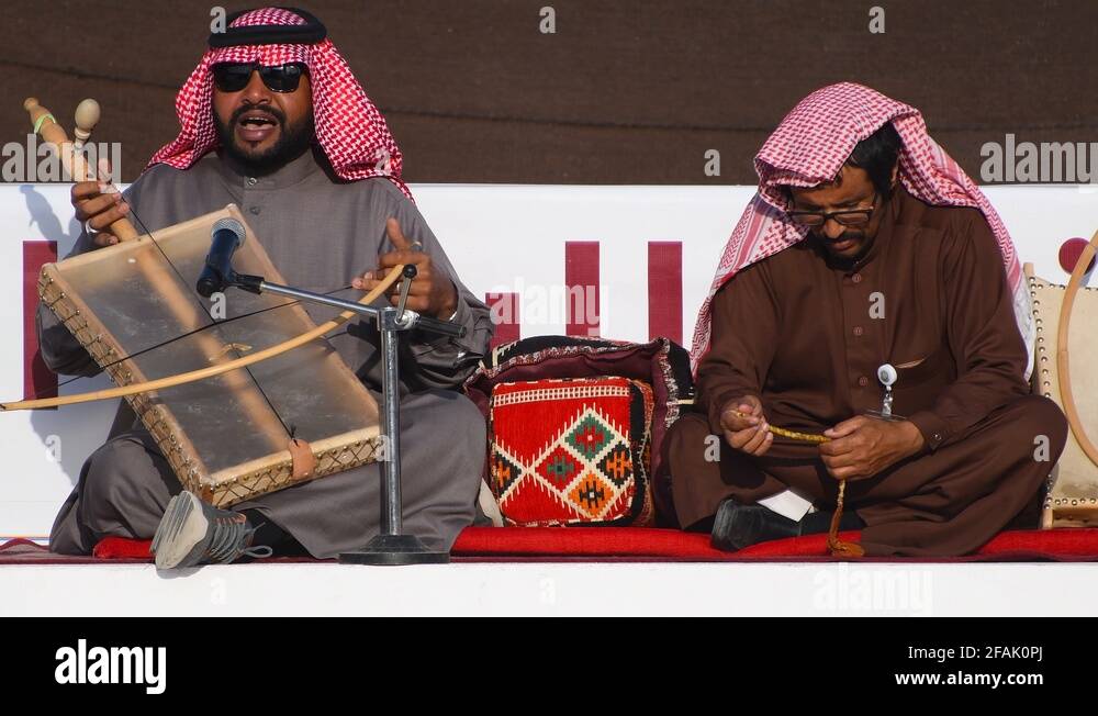 A group of men perform a traditional Saudi Arabian song with rababa ...